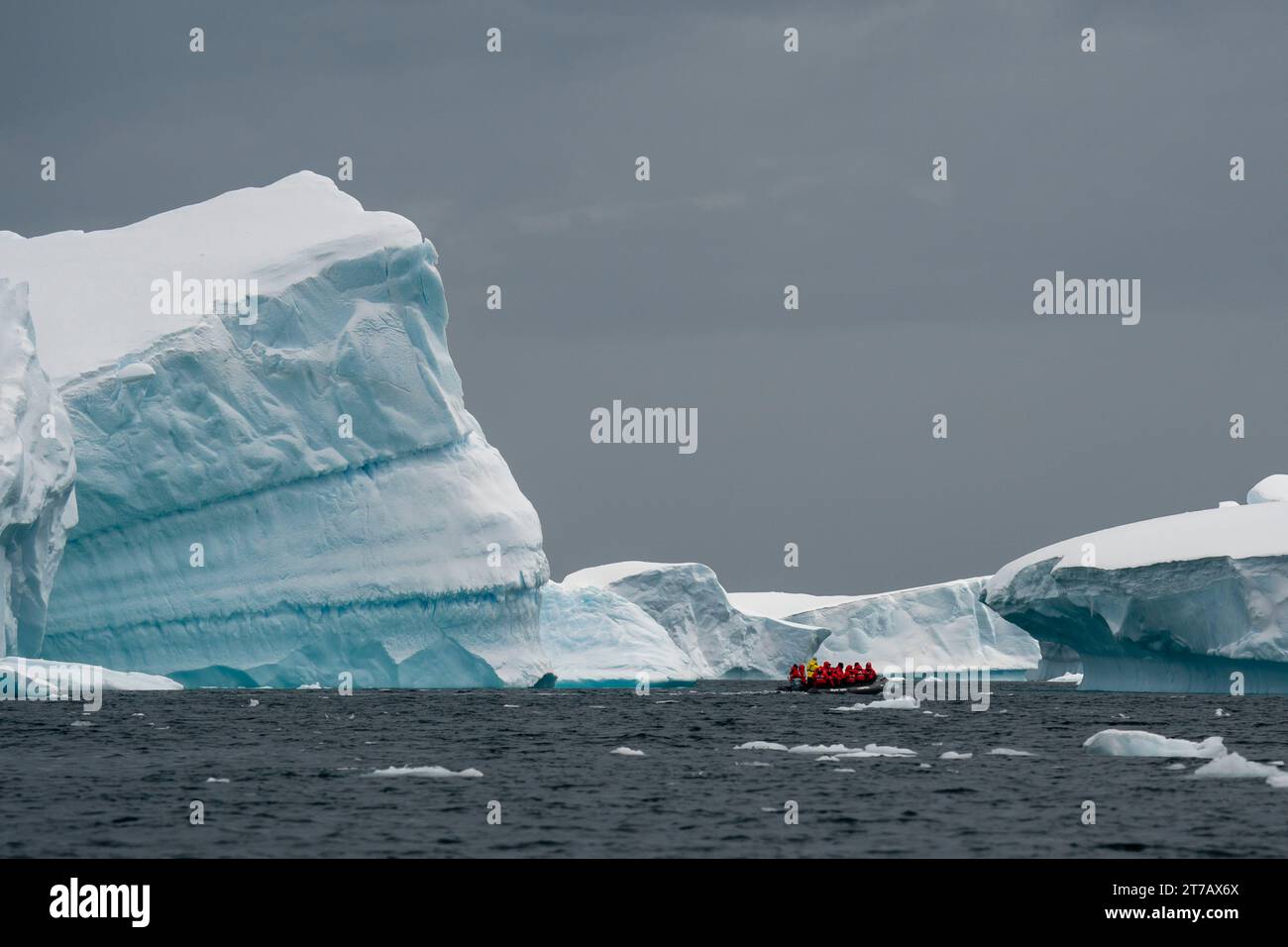 Tourists in an inflatable boat exploring Pleneau Island, Antarctica ...
