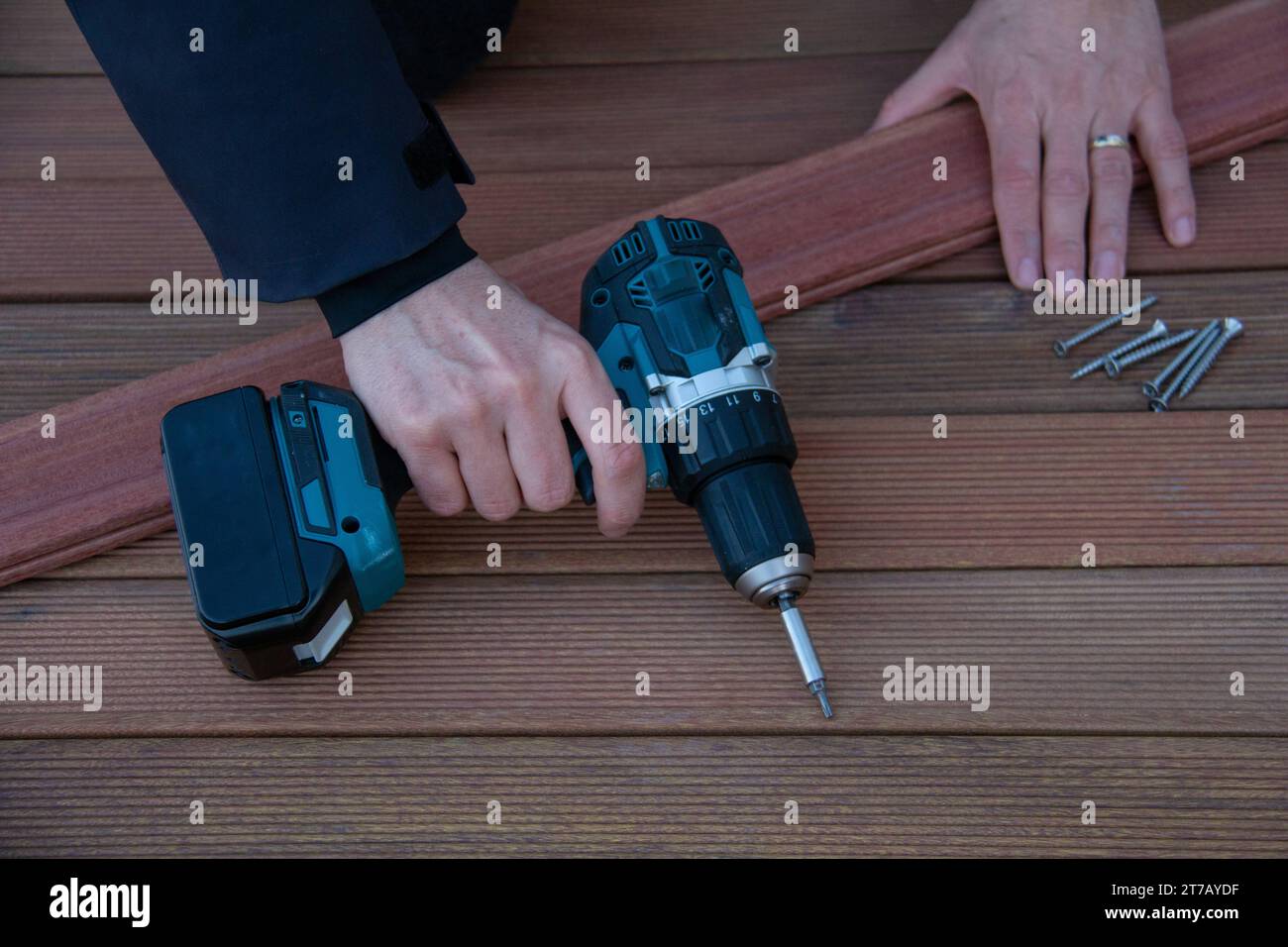 Terrace deck construction, carpenter holding tools and ipe timber board ...