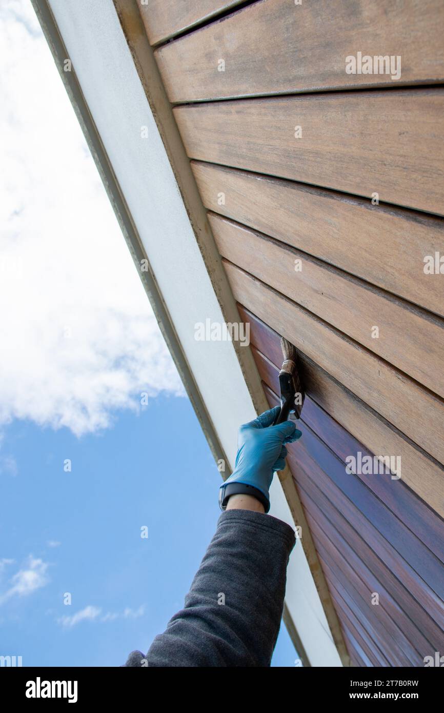 Restoration of hardwood facade siding, dramatic low angle view, hand ...