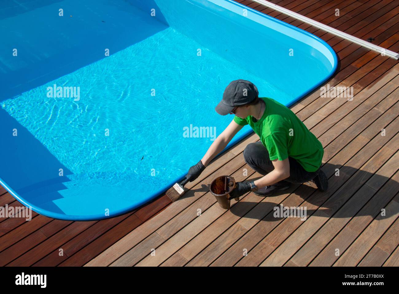 Seasonal restoration of wooden deck around the swimming pool, decking ...