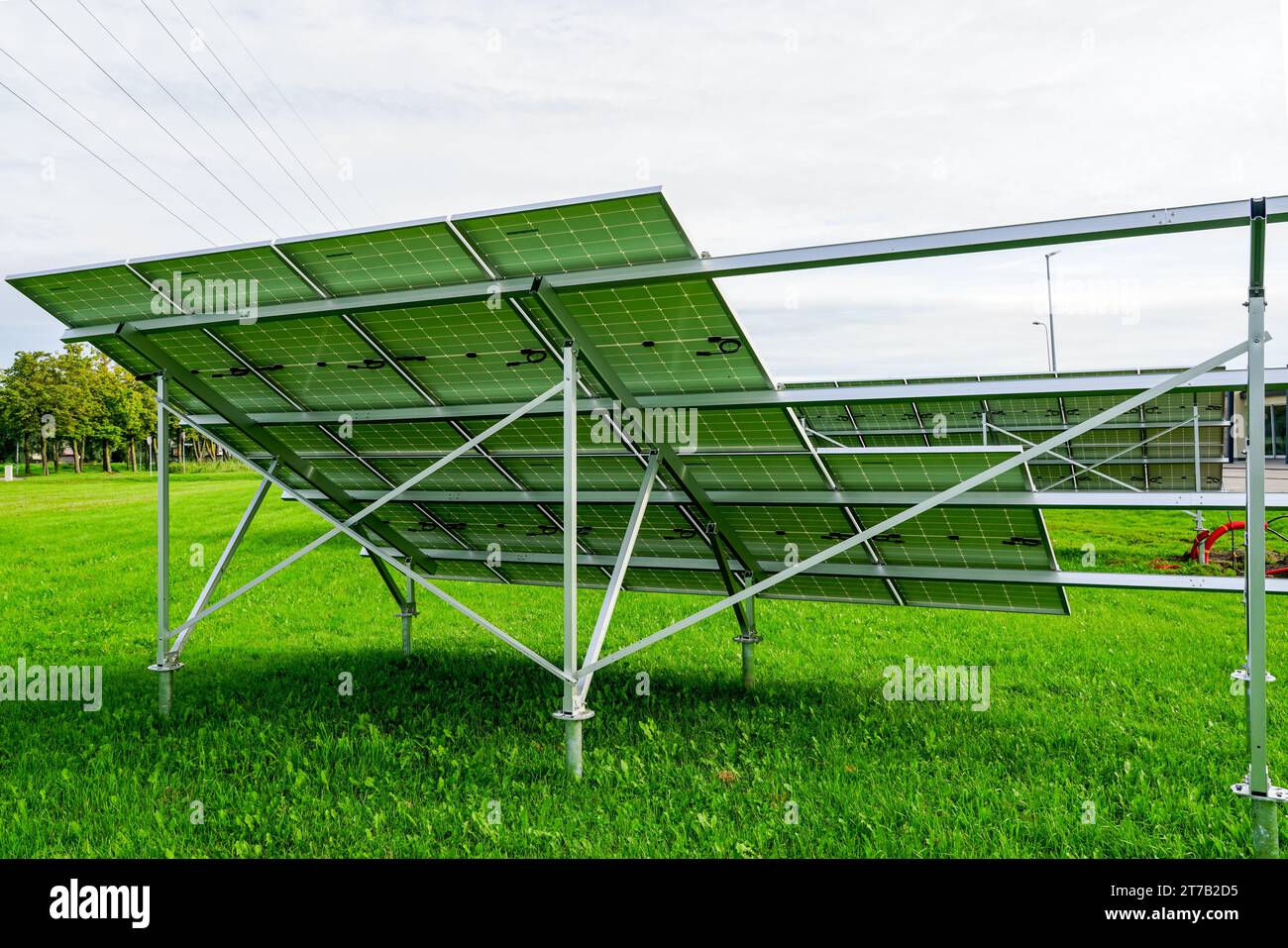 Installation of solar panels on metal frames in a green meadow ...