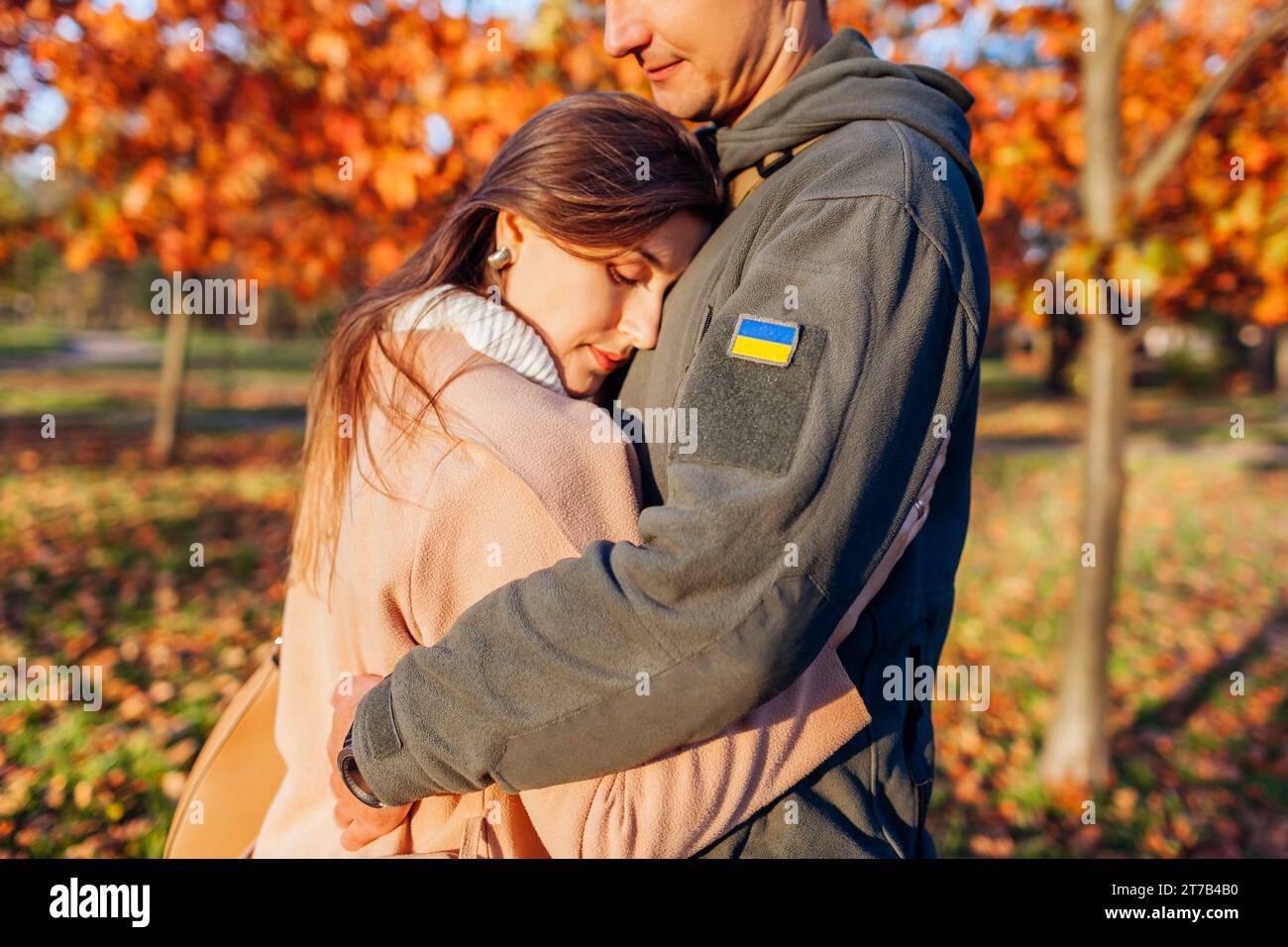 Mental health during war. Woman hugging husband in ukrainian military ...