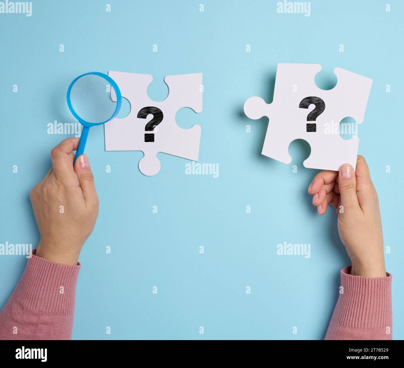 White puzzles with a question mark and a female hand holding a plastic ...