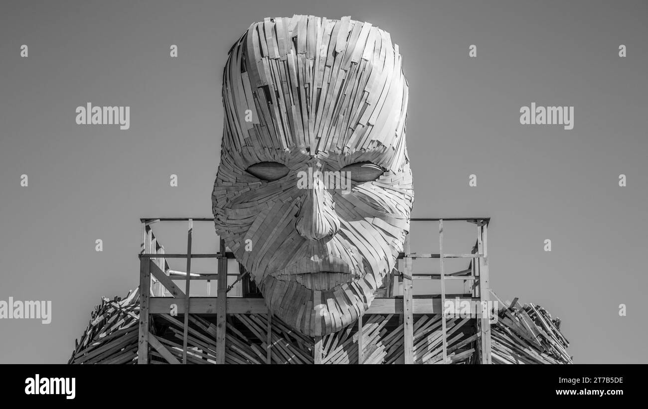 A Caucasian straw man in an upright position standing on a scaffolding ...