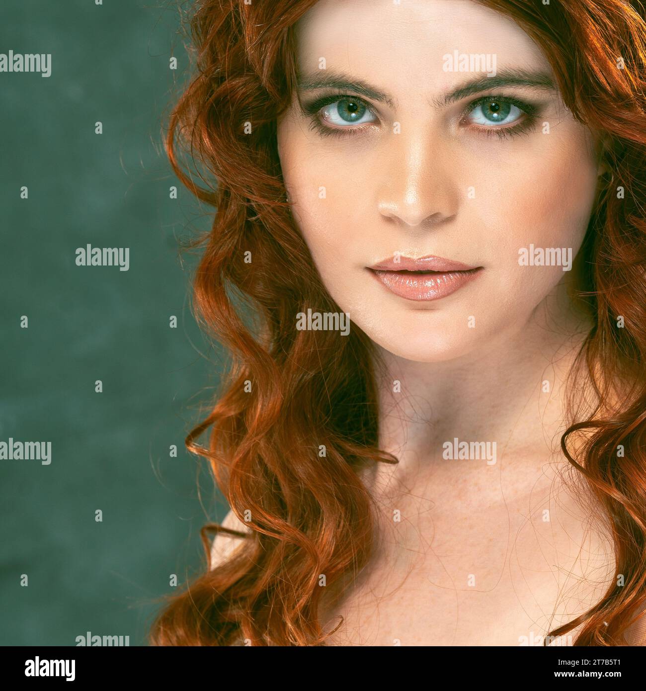 Head and chest portrait of a young red-haired woman in vibrant colours ...