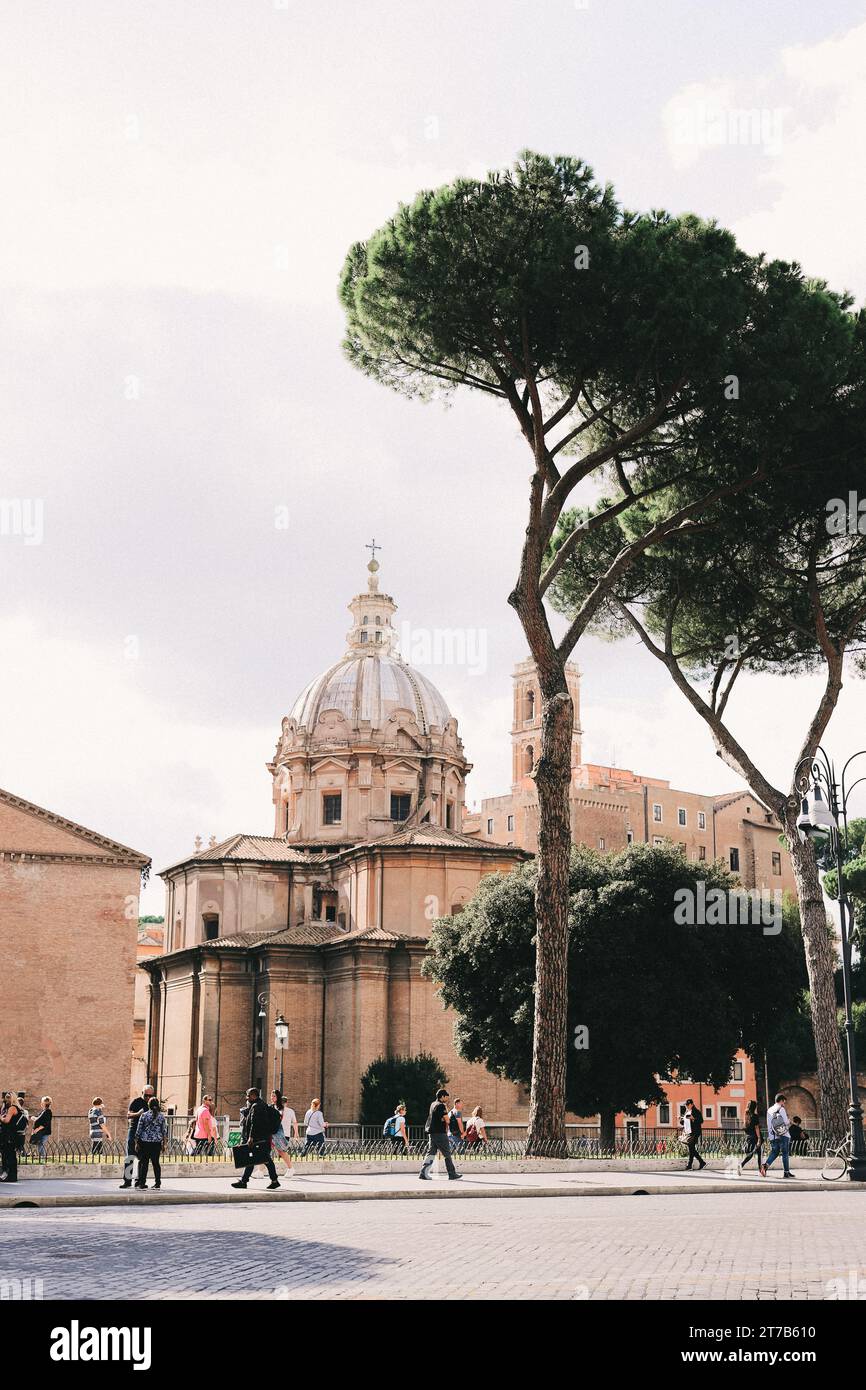 A diverse group of people are walking across a scenic plaza with an ...
