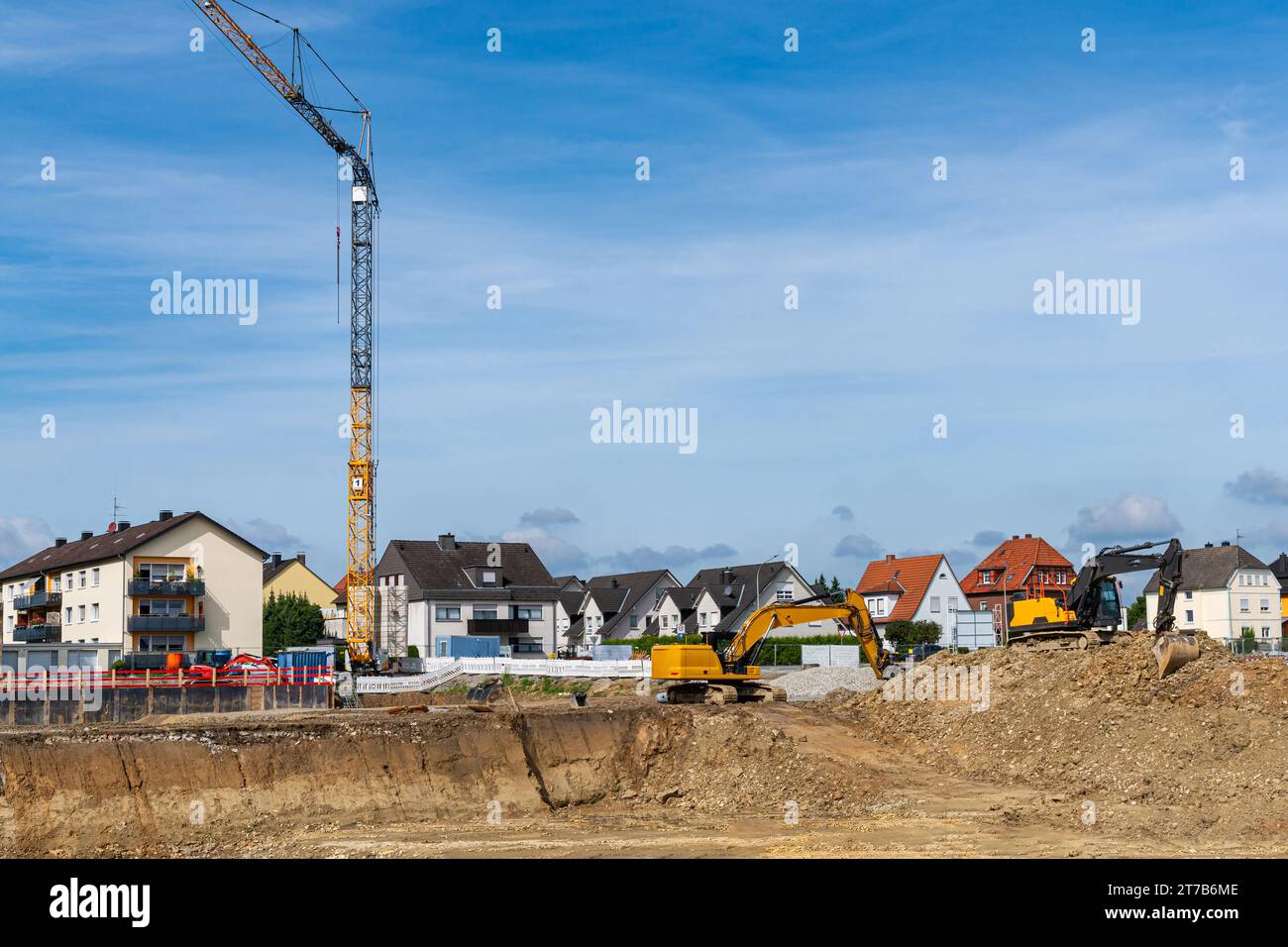 Earthworks before building construction. Excavators and tower crane at construction site ...