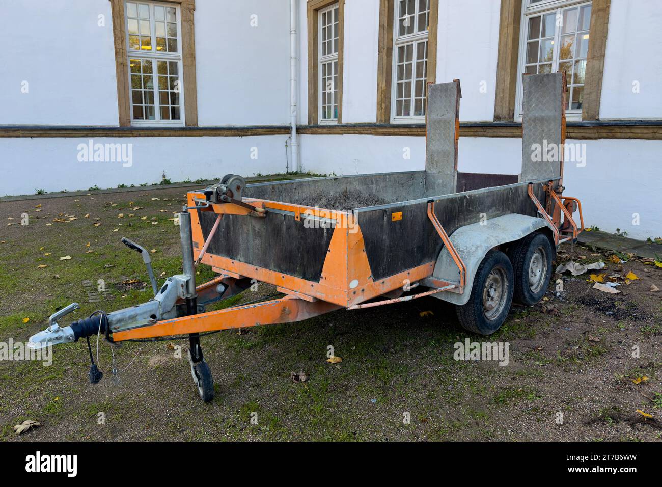 A small car trailer for transporting goods against the background of a ...