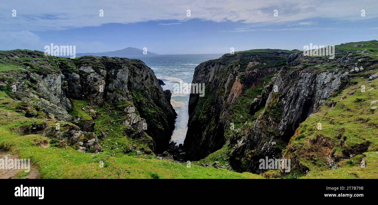 A scenic view of a cliff overlooking a body of water and land on the ...