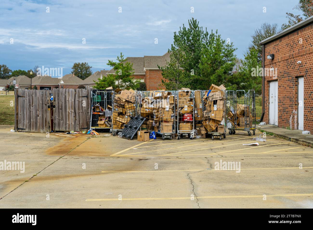 Trash and empty cardboard boxes piled up at a large dumpster with the ... Trash and empty cardboard boxes piled up at a large dumpster with the ...