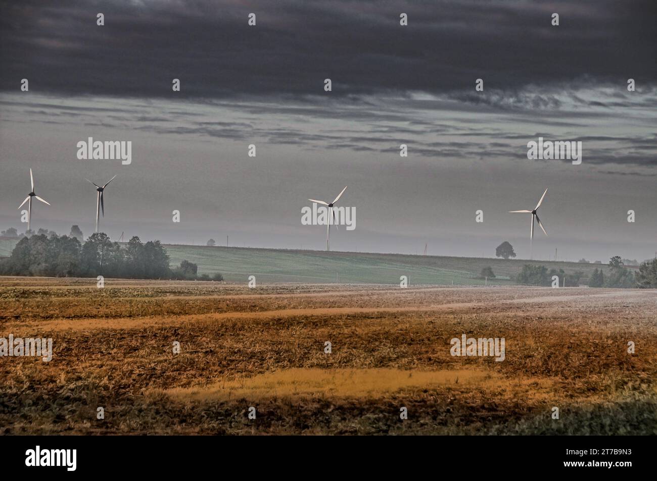 Wind turbines in a field. Cloudy sky. Stormy weather Stock Photo - Alamy