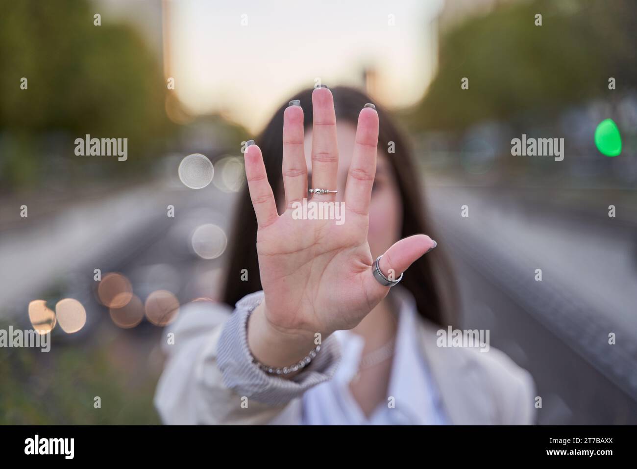 unrecognizable woman raising her hand is a sign of protest, stop ...