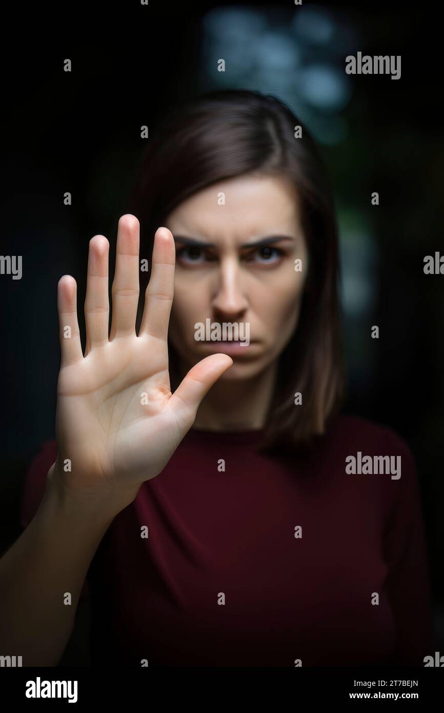A Caucasian woman's face half-hidden behind a stern hand signal for ...
