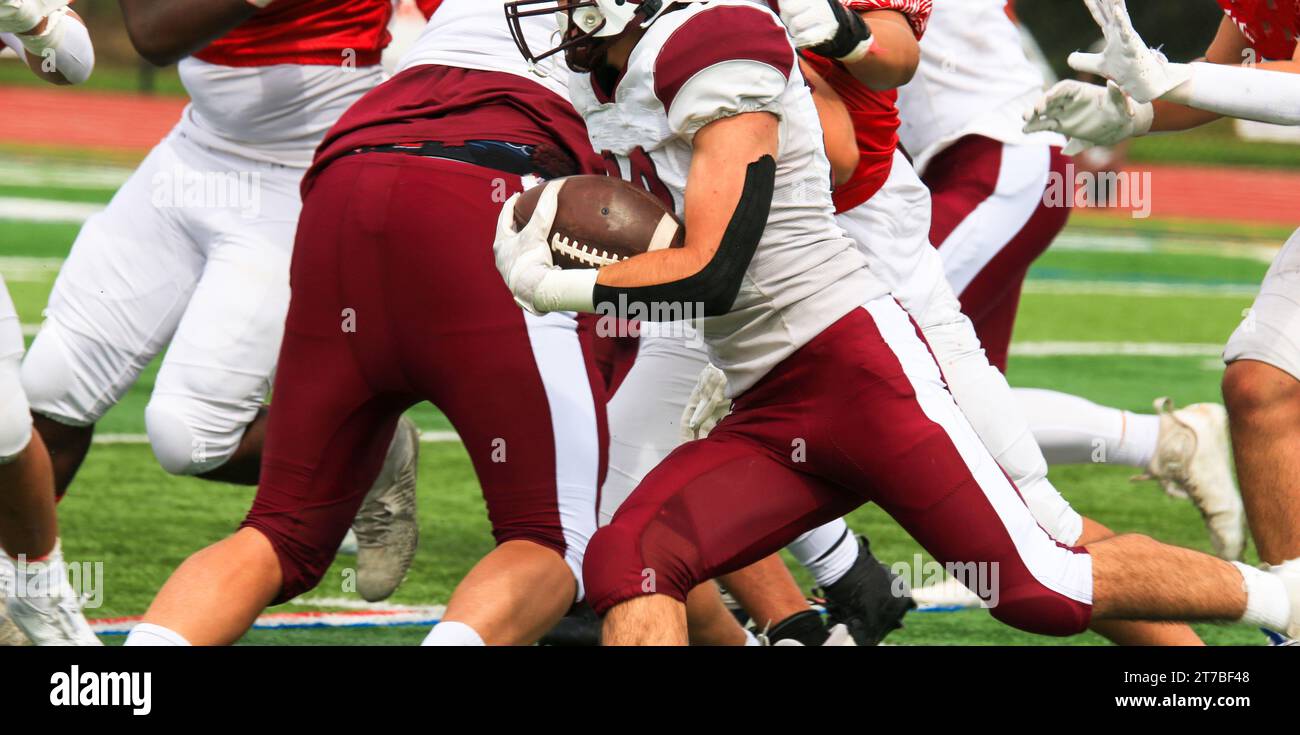 American football player running with the ball behind his blockers ...