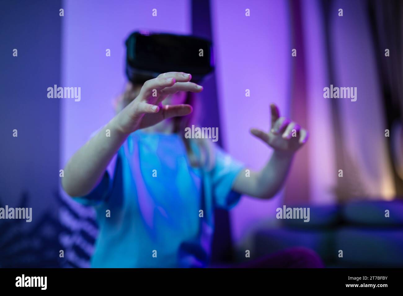 Female child using new technologies, having fun wearing virtual reality ...