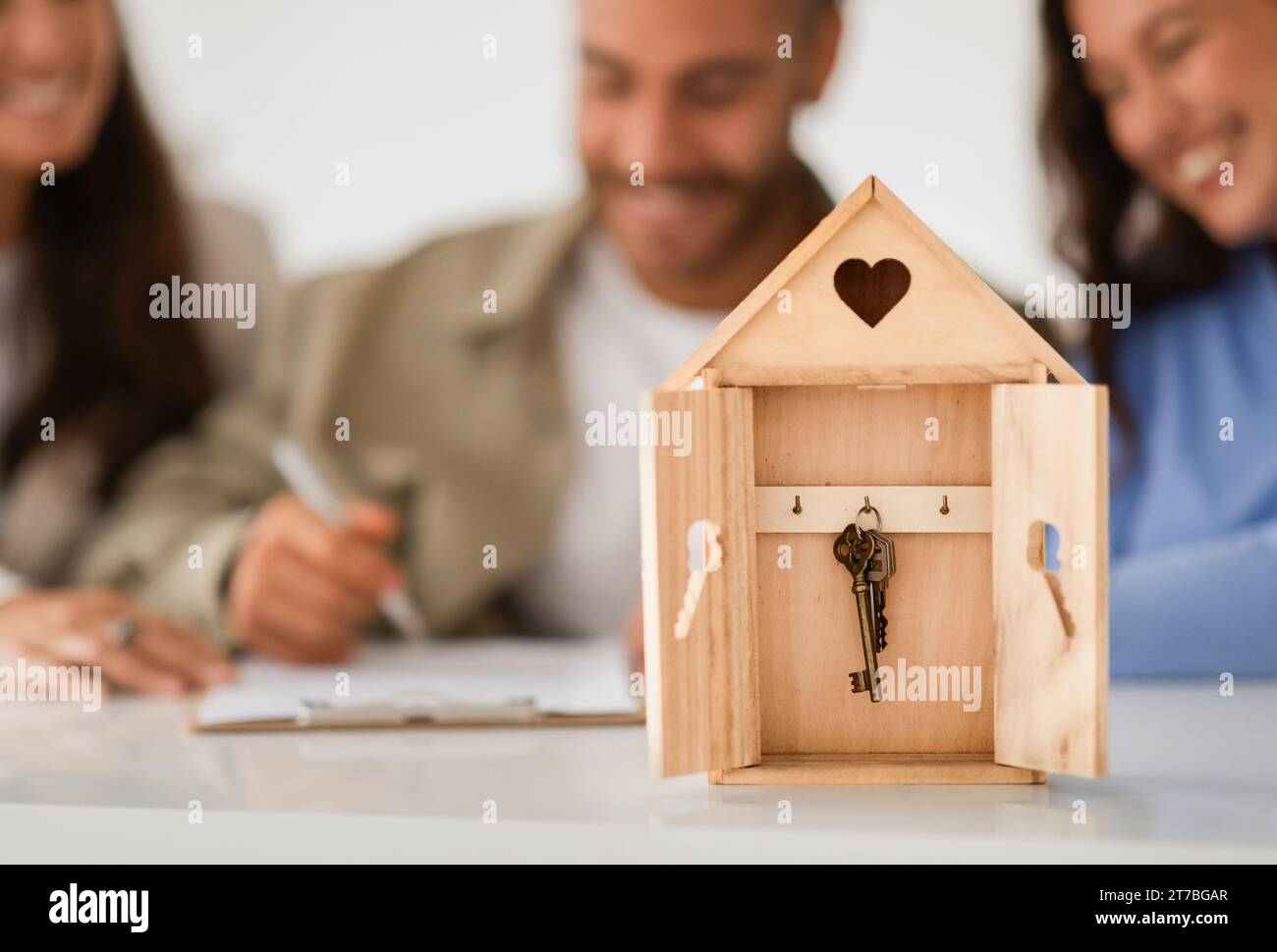 Wooden house shaped box with key inside over married couple Stock Photo ...