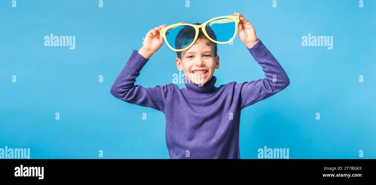Cheerful little boy generation alpha in big glasses express a surprised ...