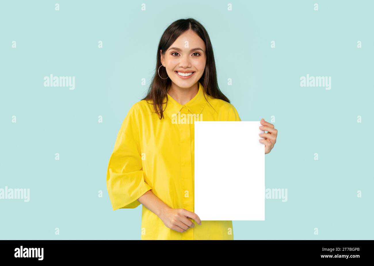 Positive millennial woman showing vertical blank placard Stock Photo ...