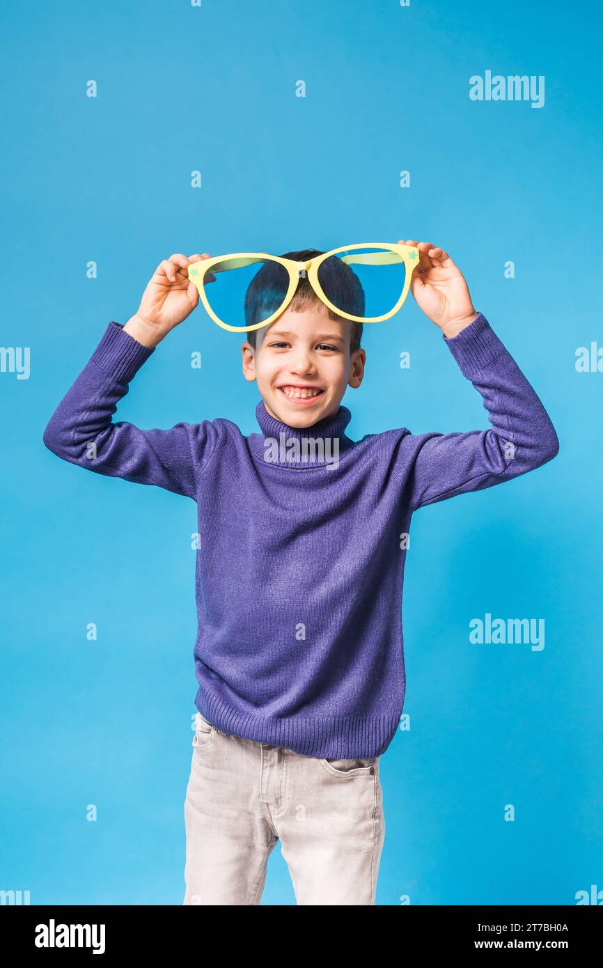 Cheerful little boy generation alpha in big glasses express a surprised ...
