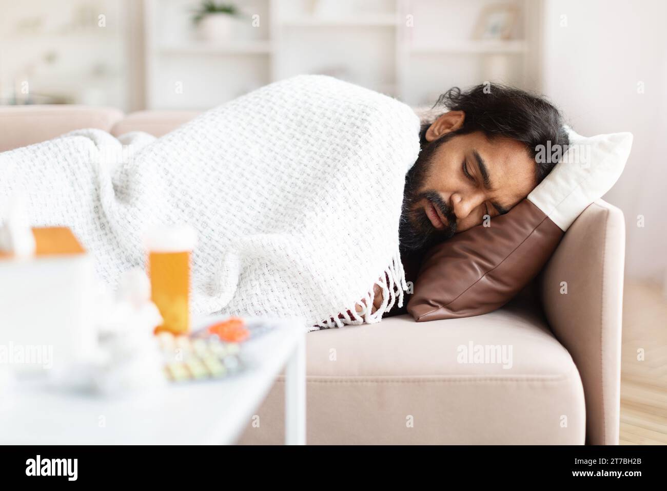 Sick Indian Guy Having Fever Lying On Couch At Home Stock Photo - Alamy