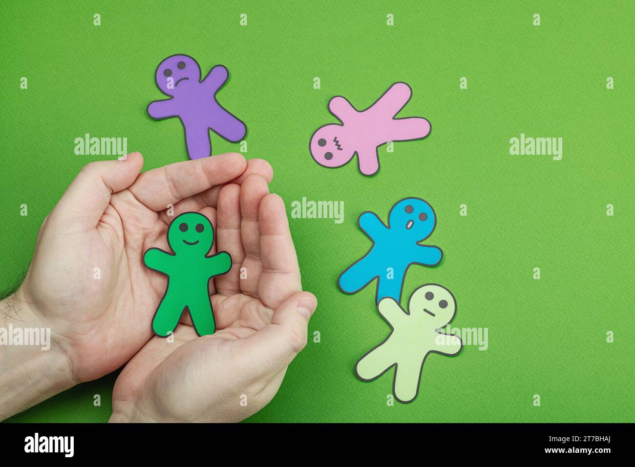 World mental health day. Male hands holding paper men figures with ...