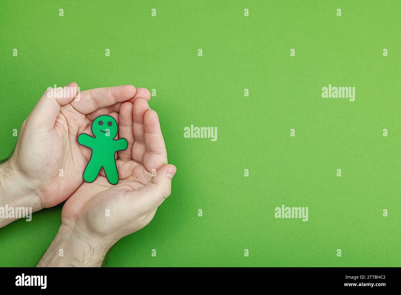 World mental health day. Male hands holding paper men figures with ...