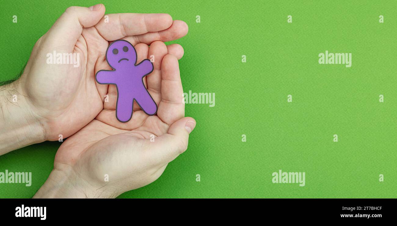 World mental health day. Male hands holding paper men figures with ...