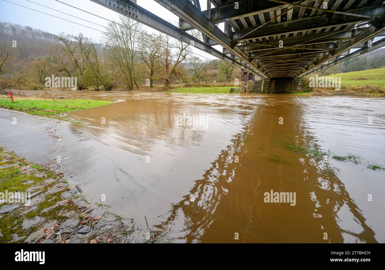 Underside of a bridge crossing brown muddied water that is flooding the ...