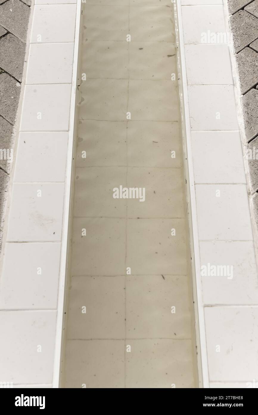 A small tiled canal with a water stream Stock Photo - Alamy