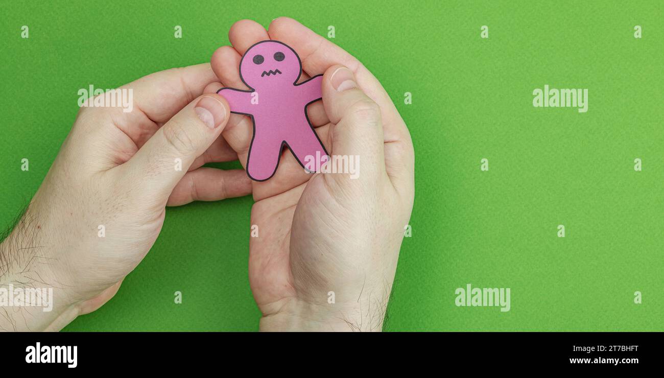 World mental health day. Male hands holding paper men figures with ...