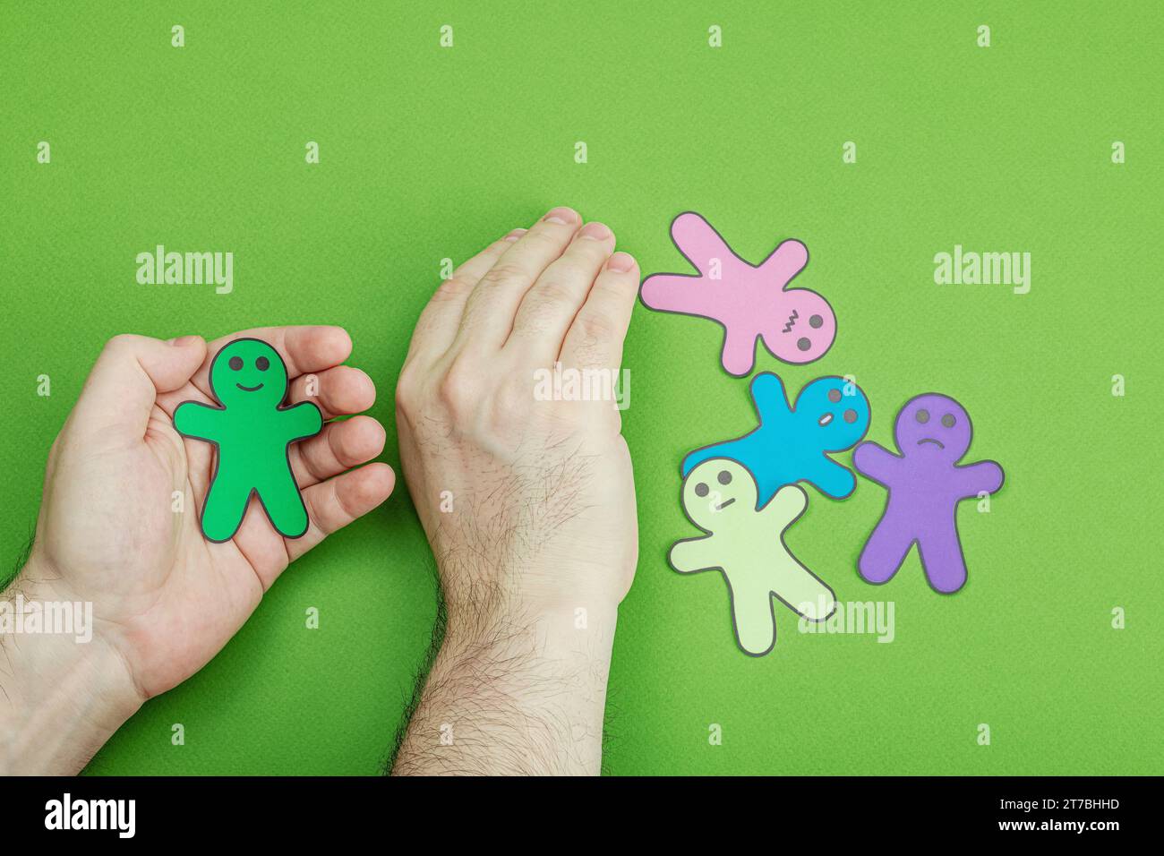 World mental health day. Male hands holding paper men figures with ...