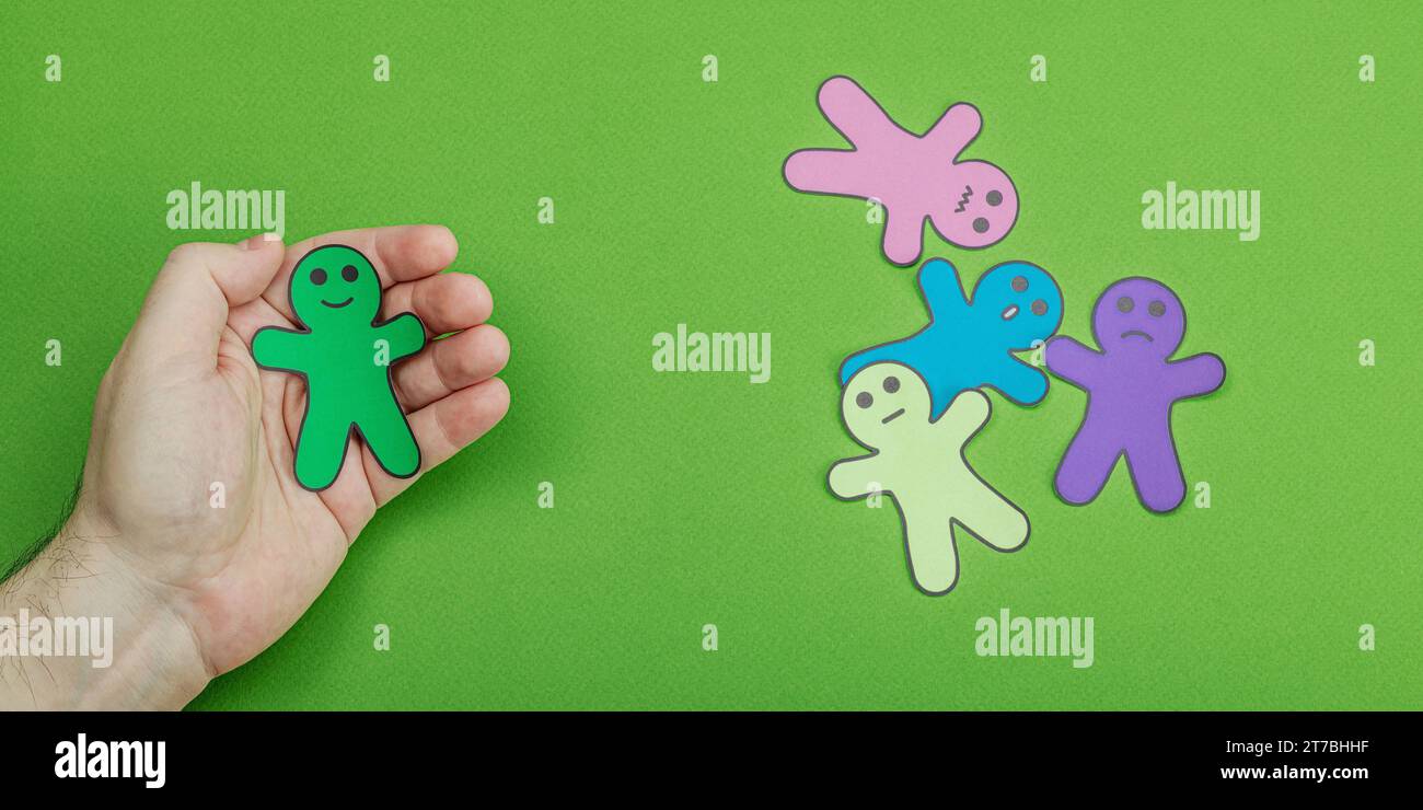 World mental health day. Male hands holding paper men figures with ...