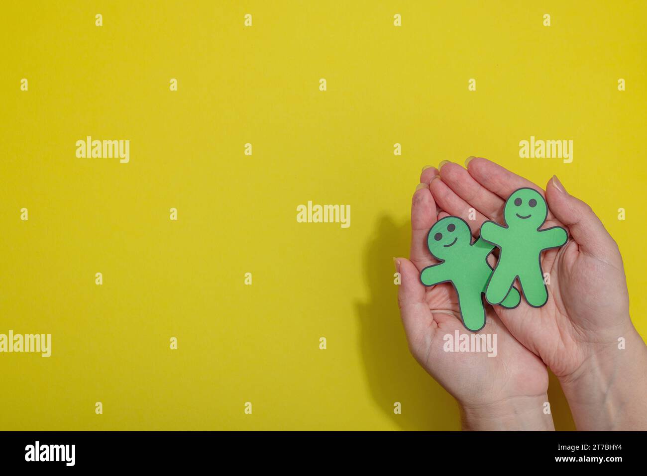World mental health day. Female hands holding paper men figures with ...