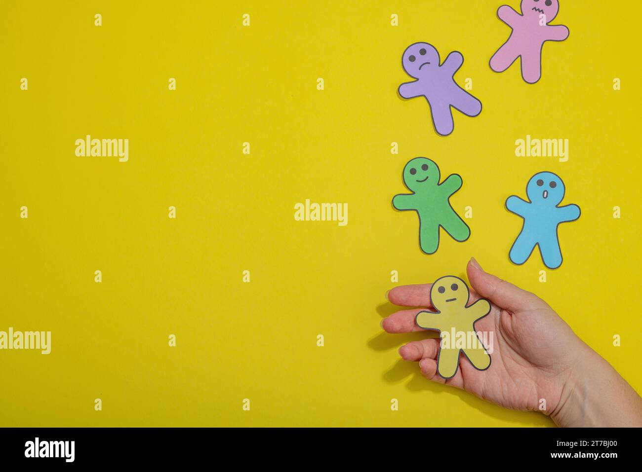 World mental health day. Female hands holding paper men figures with ...