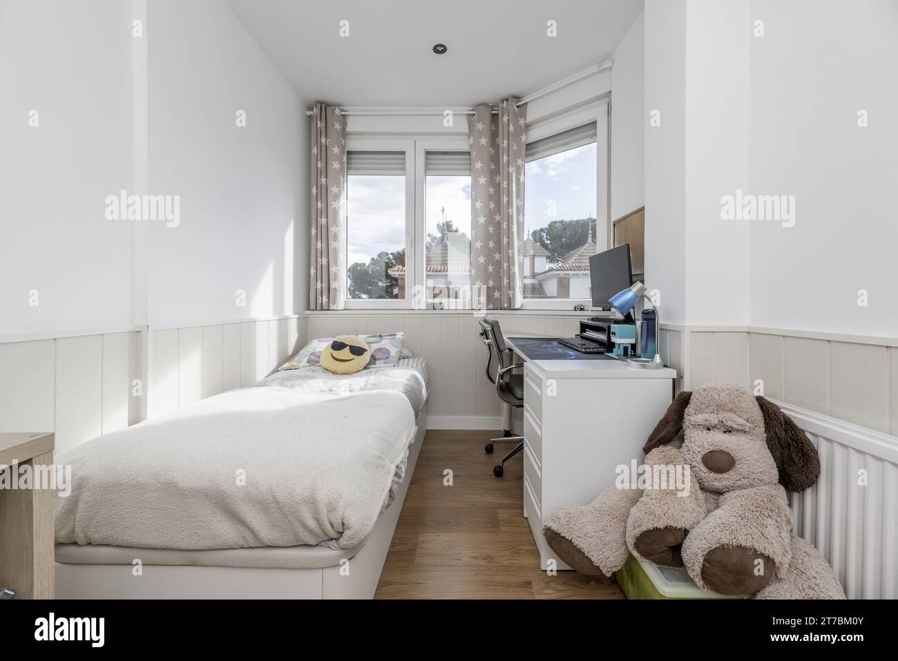 A youth bedroom with a desk under the aluminum window, white furniture ...