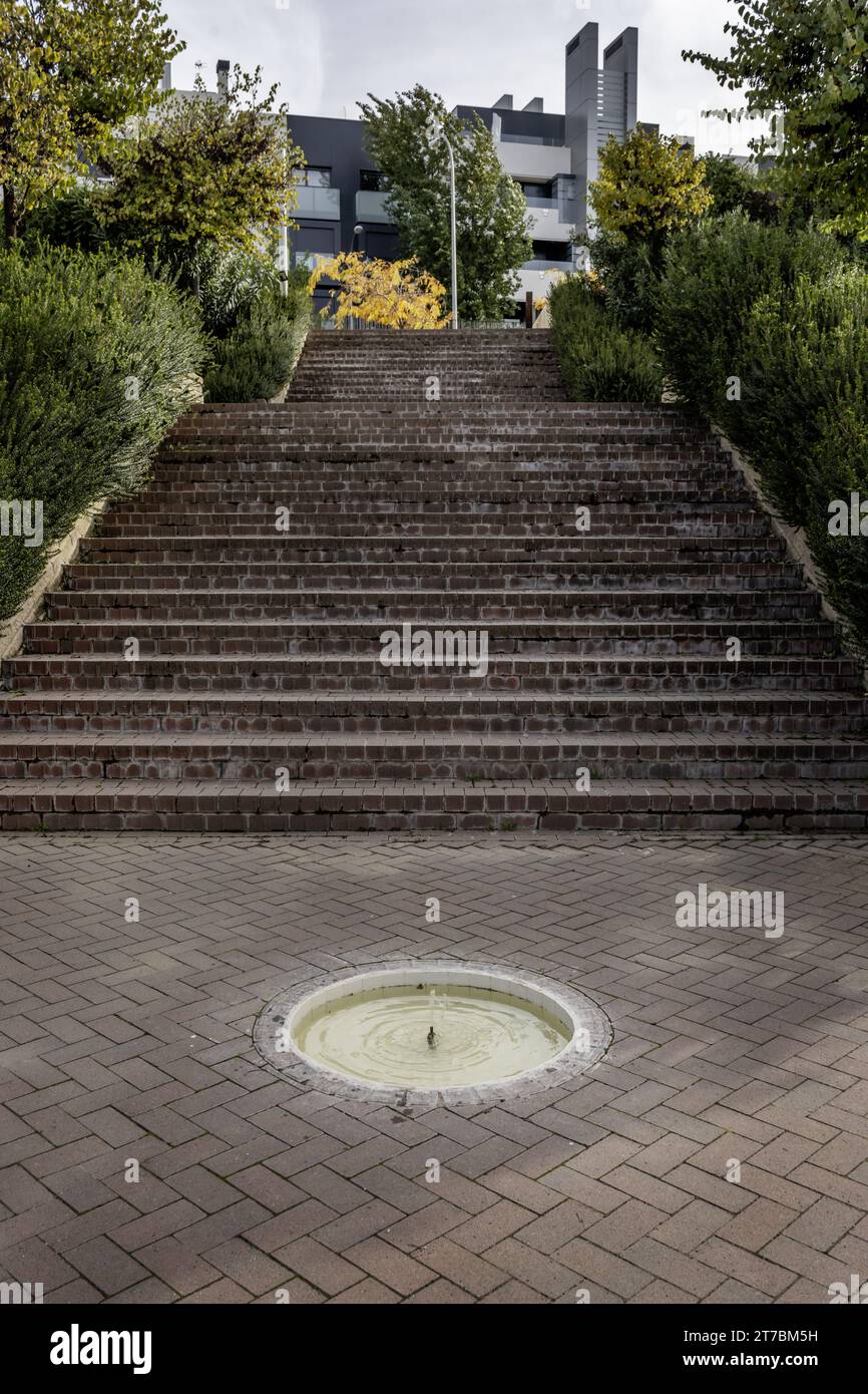 A small circular fountain on the promenade of an urban park Stock Photo ...