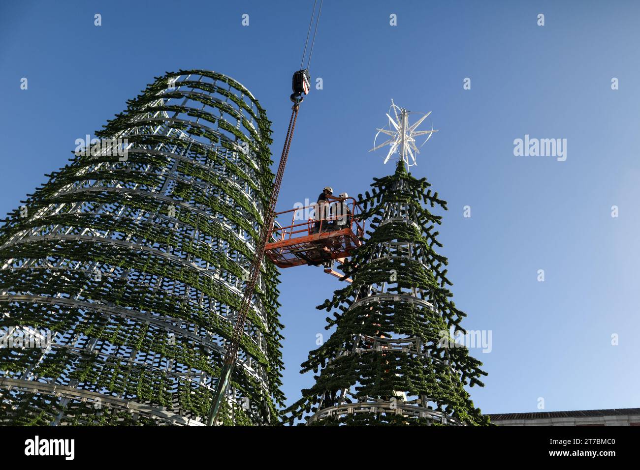 Workers install the upper cone of the Christmas tree at Puerta del Sol ...