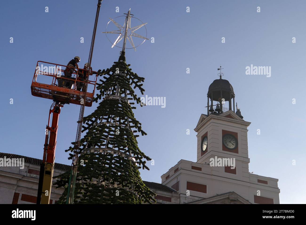 Workers install the upper cone of the Christmas tree at Puerta del Sol ...
