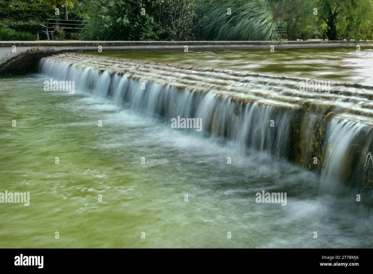 Long exposure image of a small slope with water falling into a canal ...