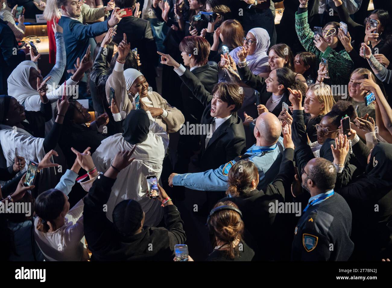 SEVENTEEN group members dance amid the crowd during a show at Unesco in ...