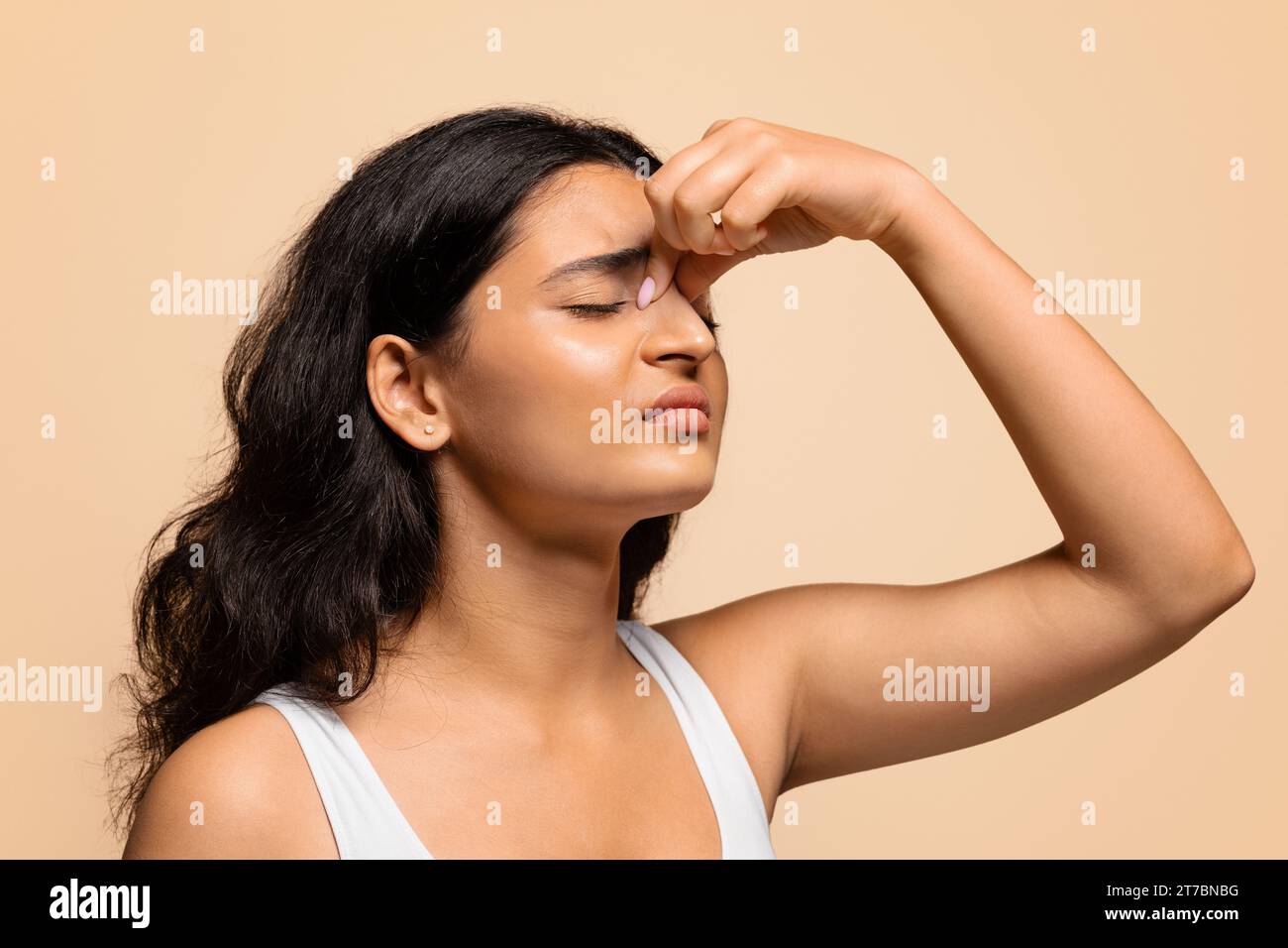 Nosebleeds concept. Young indian woman with closed eyes touching nose ...