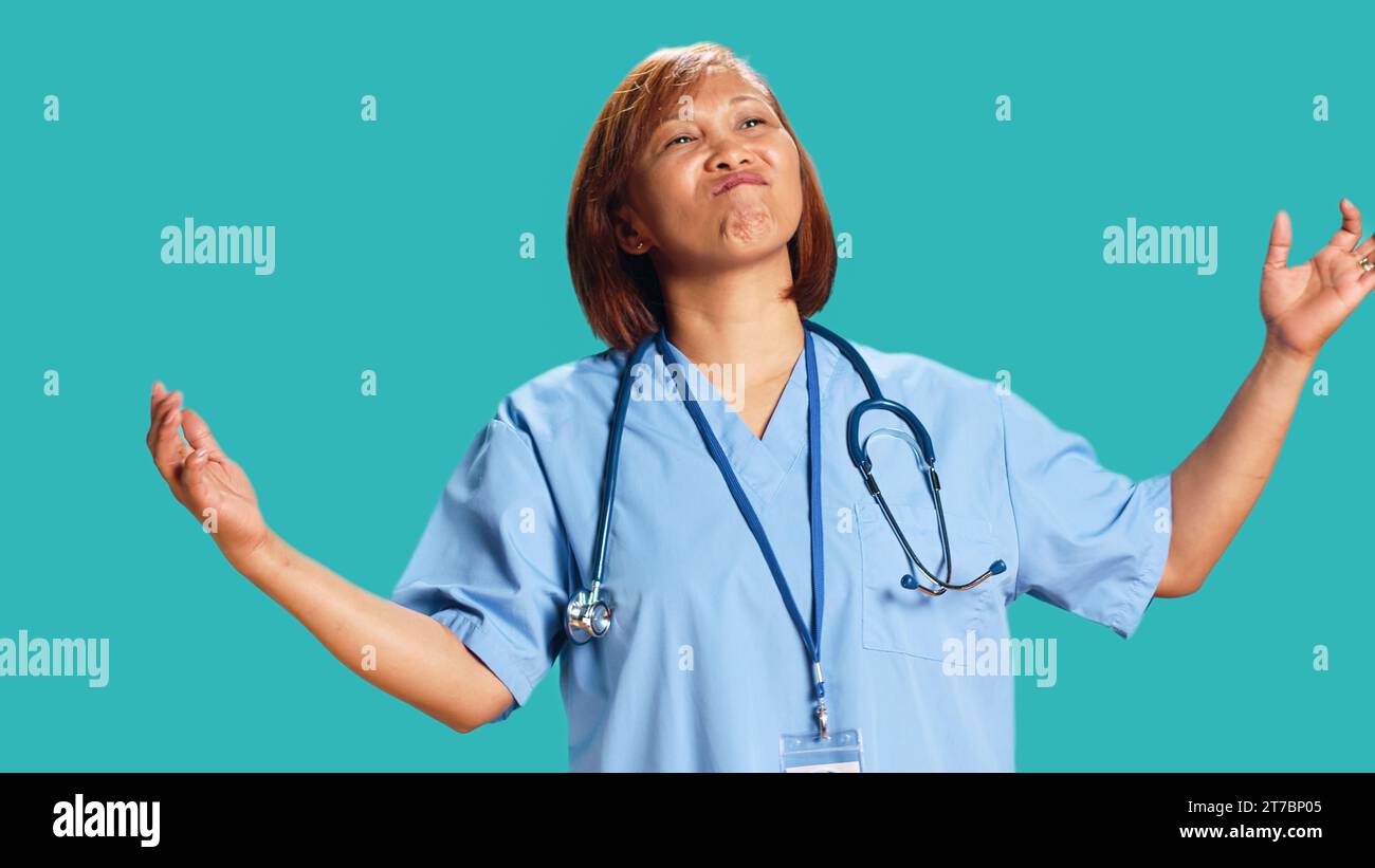 Close up shot of conflicted BIPOC nurse doing perplexed gesturing while ...