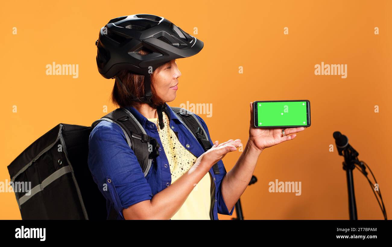 BIPOC woman holding chroma key green screen phone, showing thumbs up ...