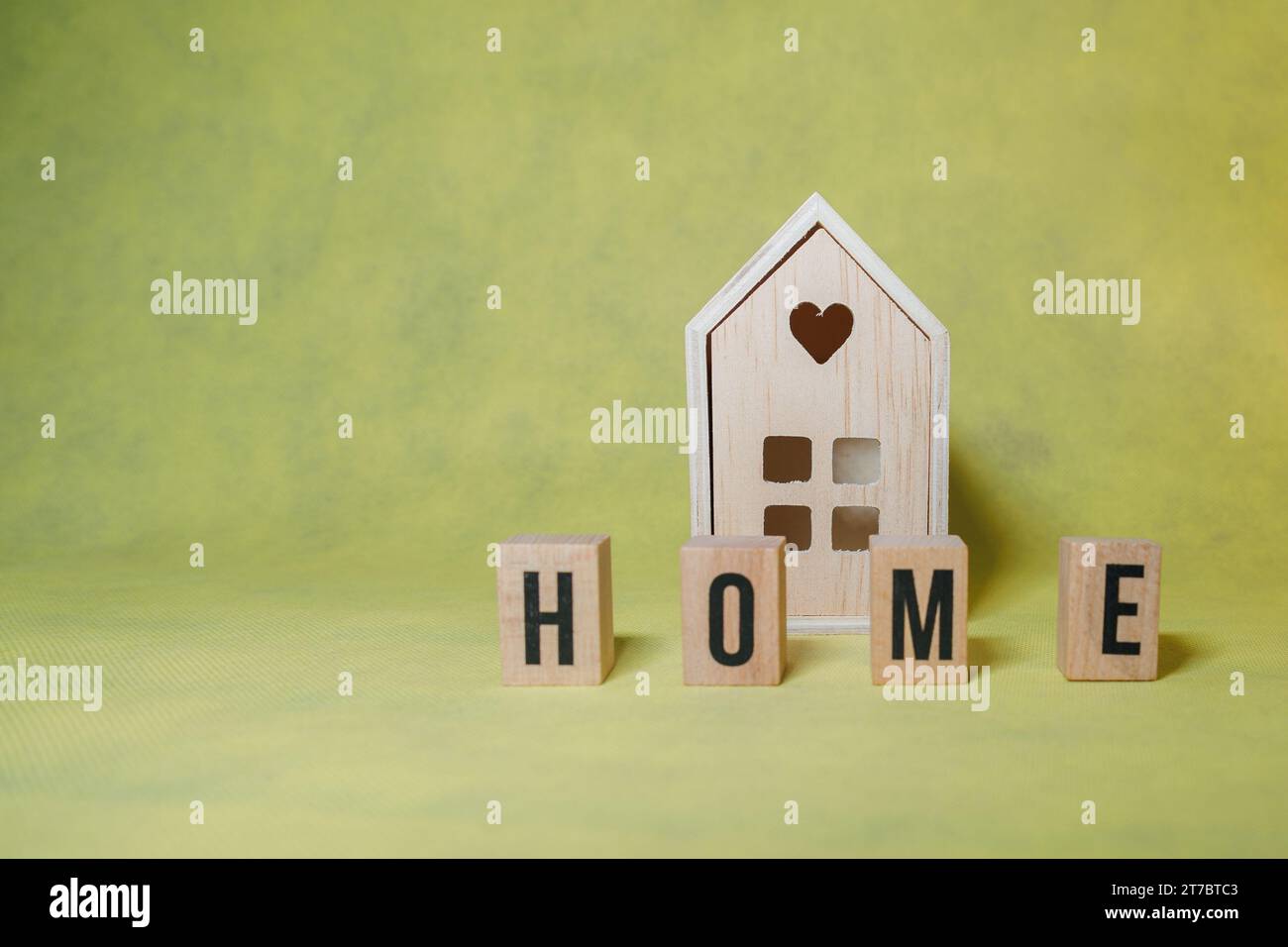 Wooden house with wooden letters forming the word HOME as a concept ...