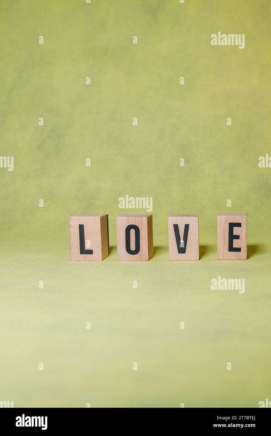 word LOVE constructed by wooden letters on yellow background with copy ...