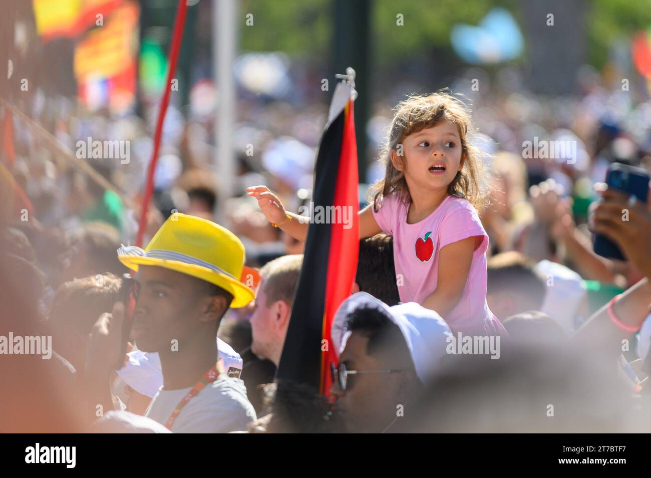 A little girl on the shoulders of somebody among the crowd of pilgrims ...