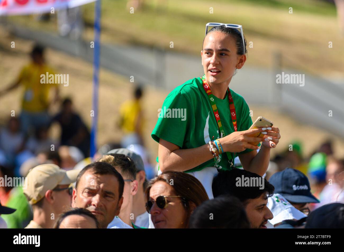 A girl on the shoulders of somebody among the crowd of pilgrims at the ...