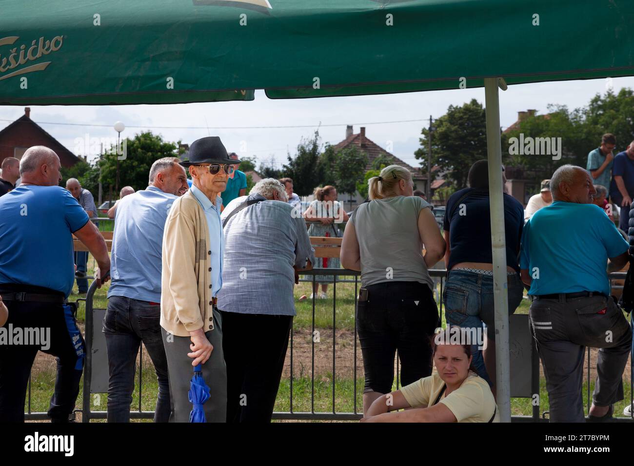 Picture of a senior old man standing with sunglasses and hat in a crowd ...