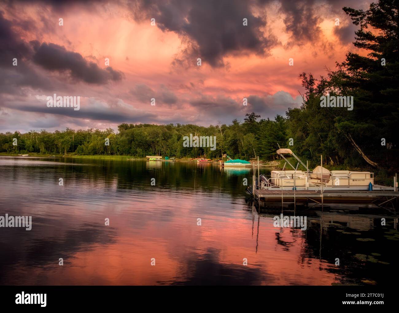 Colorful lakeshore dramatic clouds pontoon and boats reflection in the ...