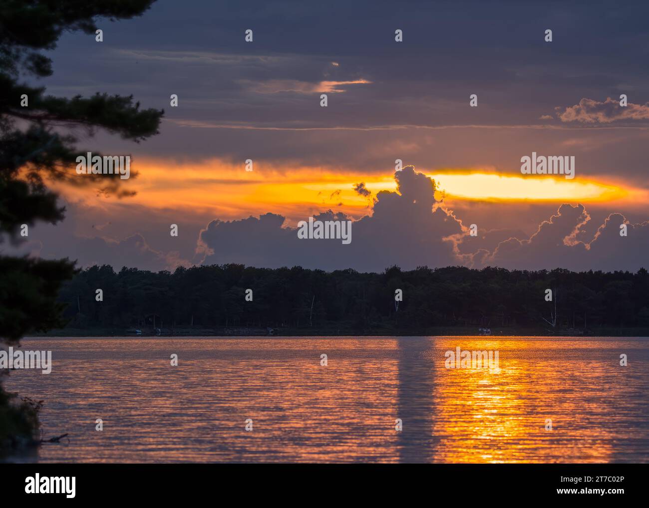 Sunsetting through clouds on lake golden hour on remote lake in the ...